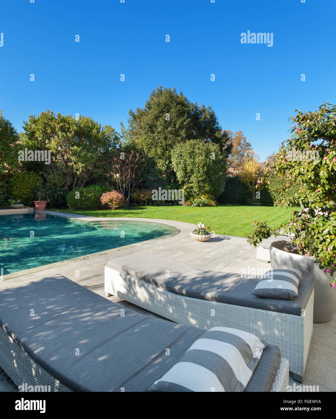 Architecture; beautiful garden with pool, two sunbeds view Stock Photo ...