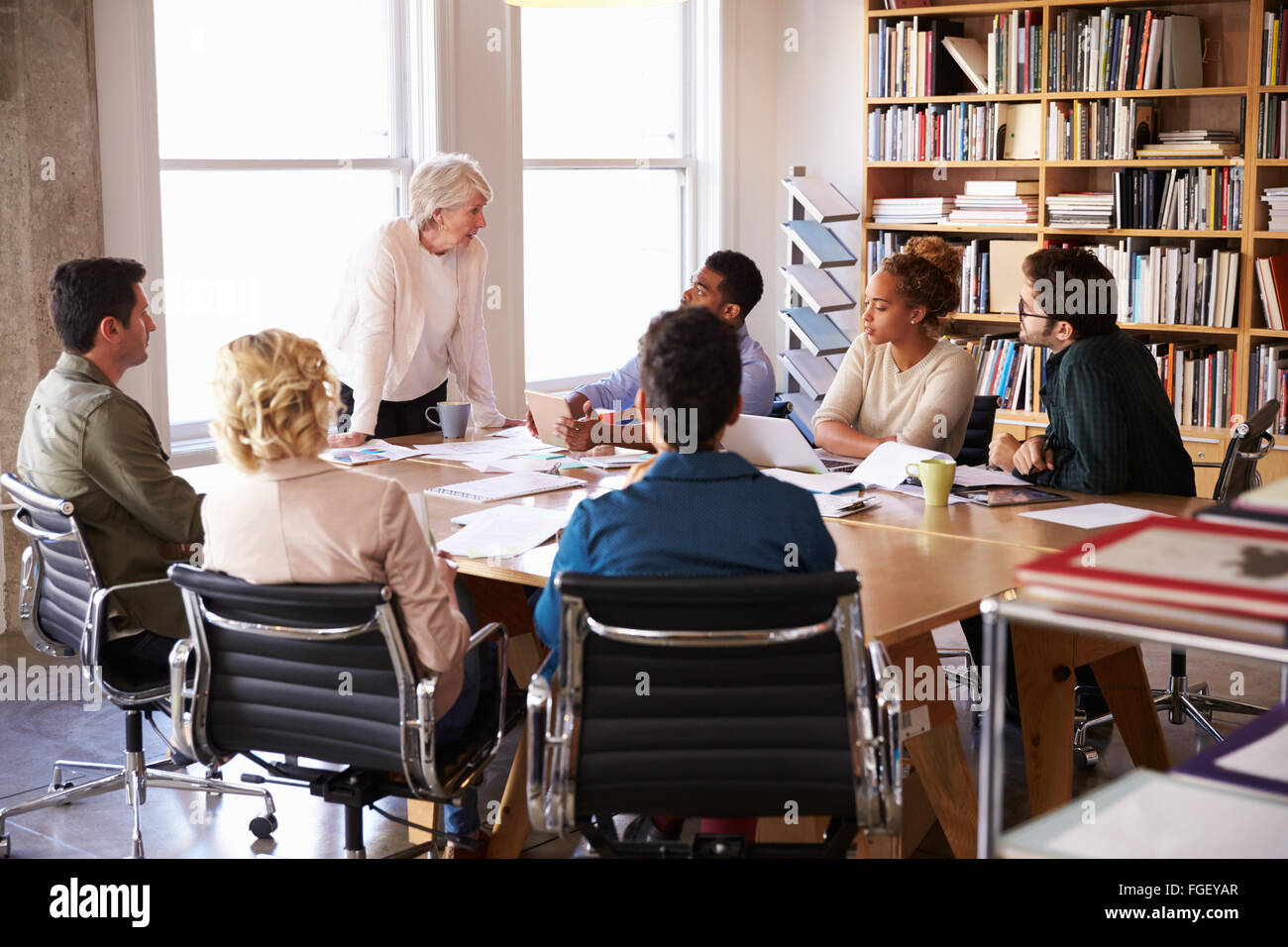 Senior Businesswoman Addressing Team Meeting Around Table Stock Photo ...