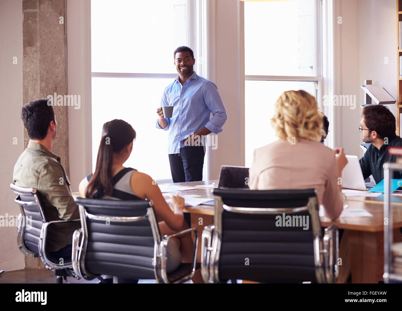 Businessman Addressing Team Meeting Around Table Stock Photo - Alamy