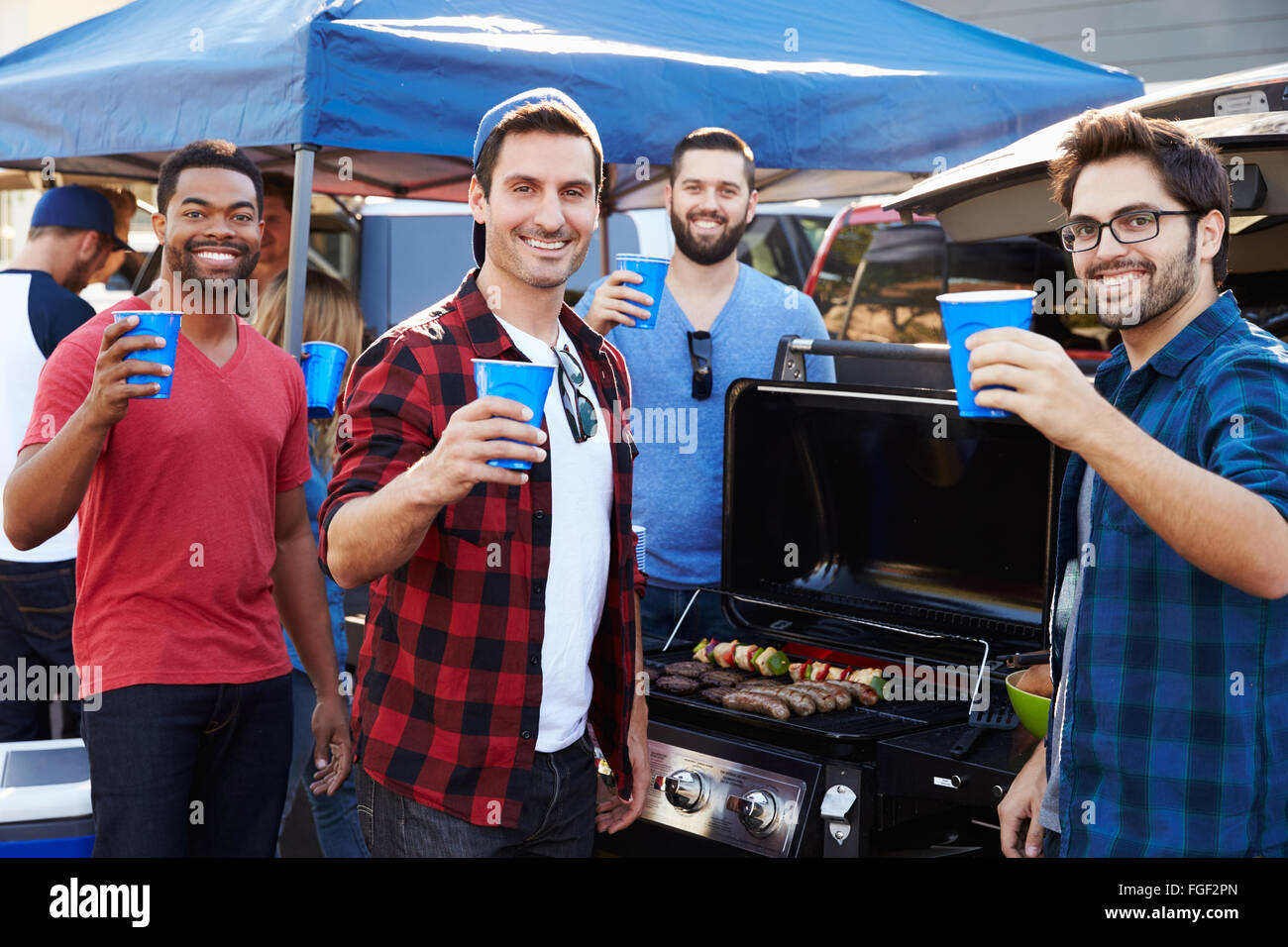 Group Of Male Sports Fans Tailgating In Stadium Car Park Stock Photo ...