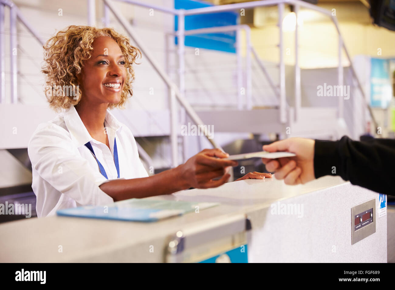 Staff At Airport Check In Desk Handing Ticket To Passenger Stock Photo ...