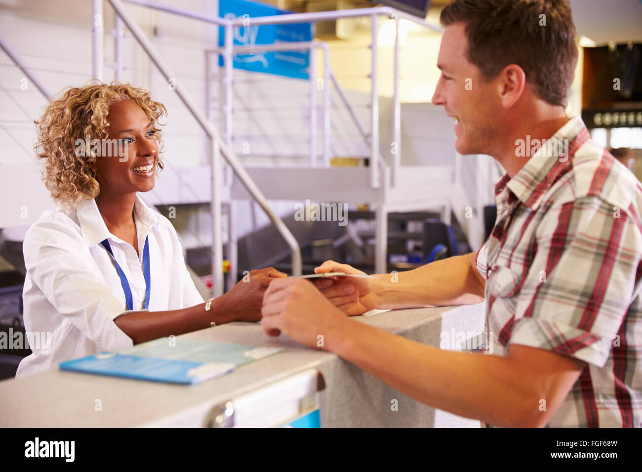 Staff At Airport Check In Desk Handing Ticket To Passenger Stock Photo ...