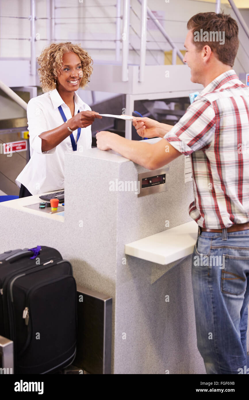 Staff At Airport Check In Desk Handing Ticket To Passenger Stock Photo ...