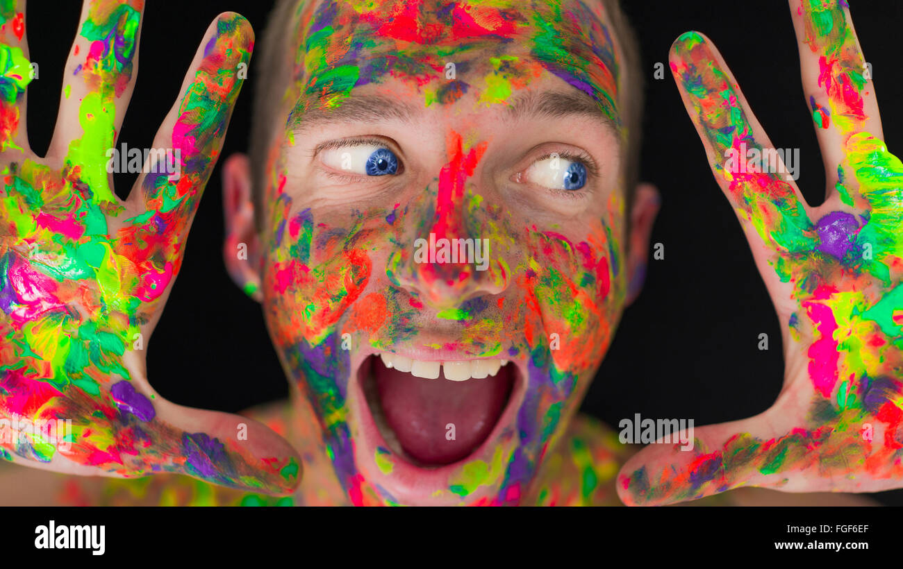 Close up of a man's face covered in coloured paint Stock Photo - Alamy