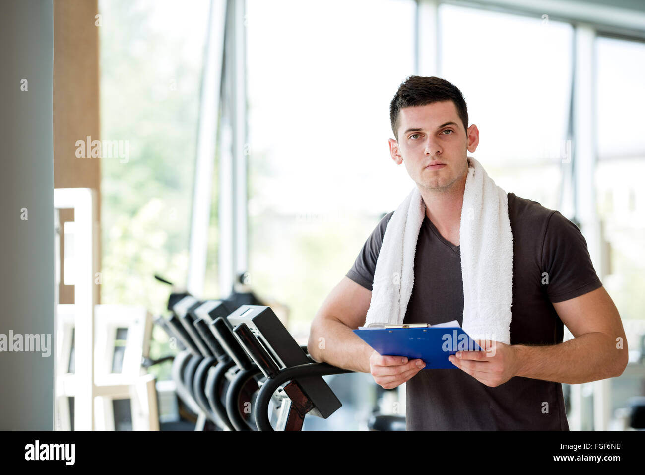 trainer with clipboard standing in a bright gym Stock Photo - Alamy