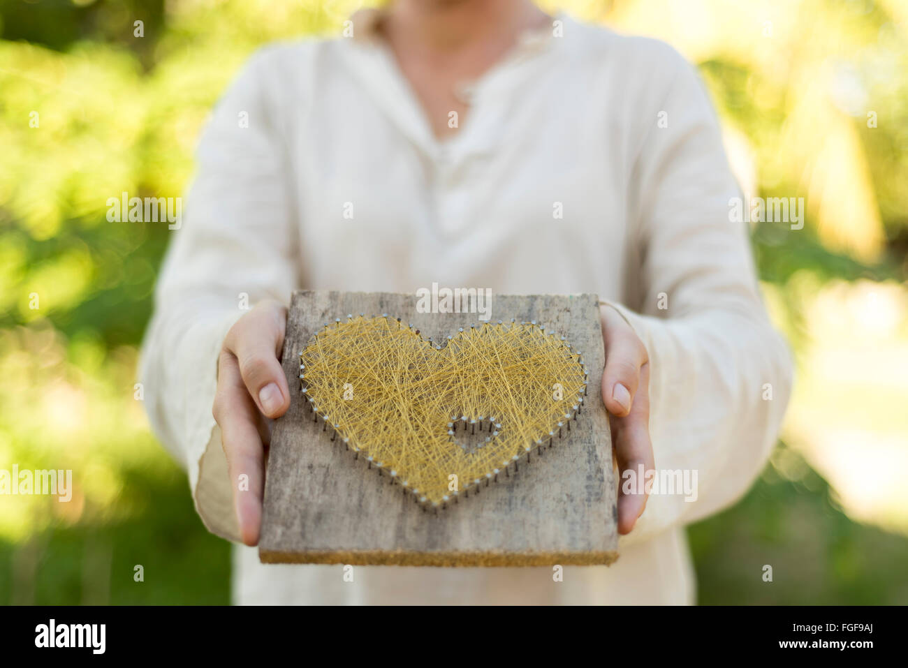 Young caucasian girl offering symbolic heart with closed hands and half ...
