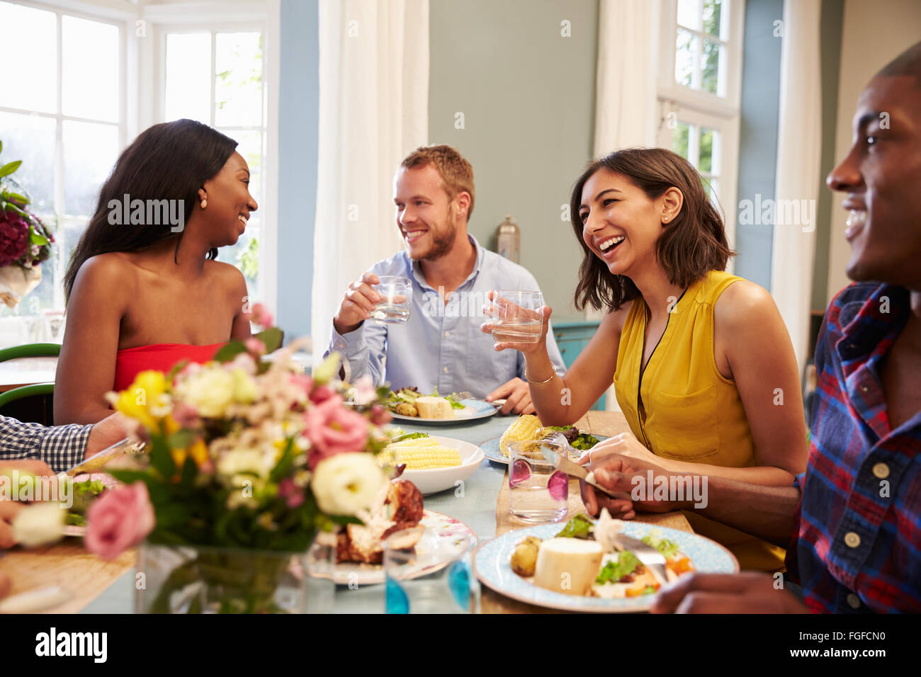 Friends At Home Sitting Around Table For Dinner Party Stock Photo - Alamy