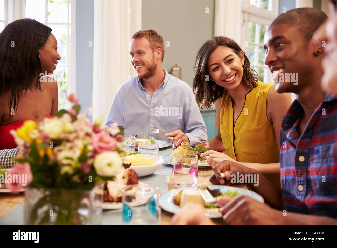 Friends At Home Sitting Around Table For Dinner Party Stock Photo - Alamy