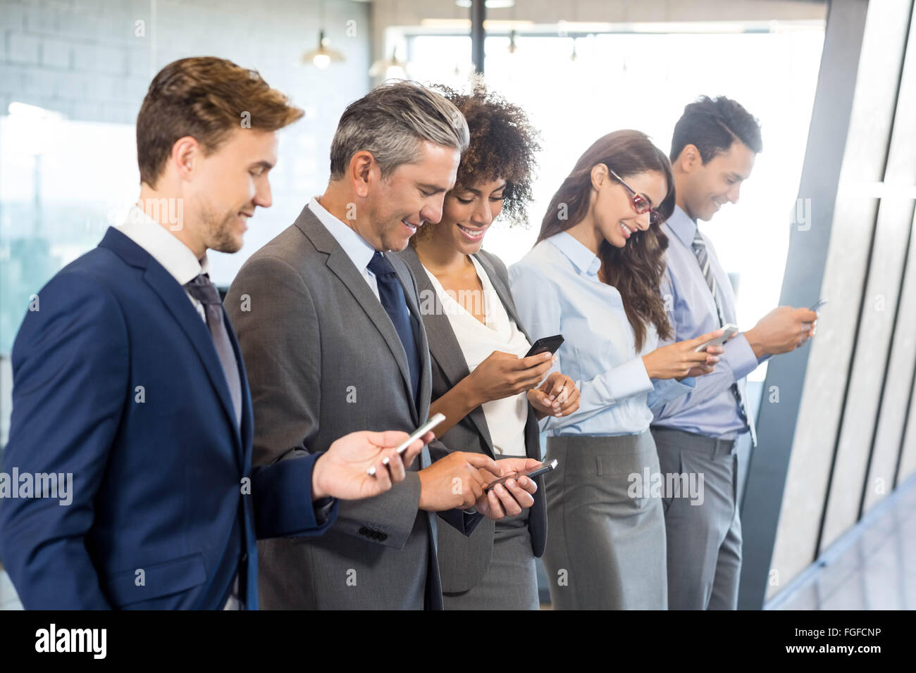 Business team using their mobile phone Stock Photo - Alamy