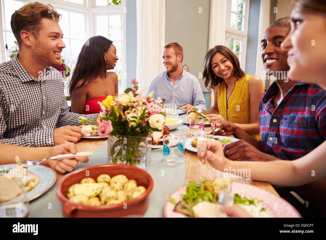 Friends At Home Sitting Around Table For Dinner Party Stock Photo - Alamy