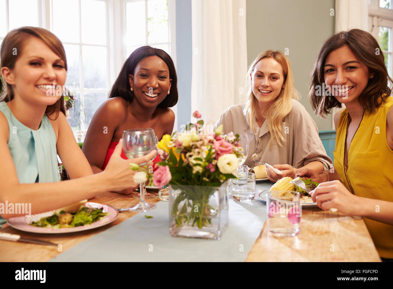 Female Friends At Home Sitting Around Table For Dinner Party Stock ...