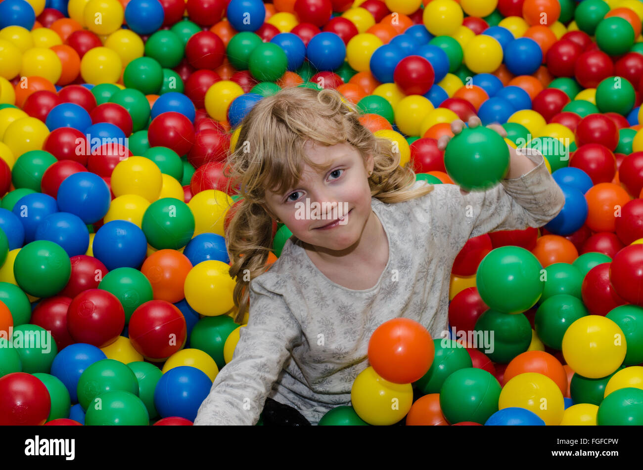 happy blond child girl playing with colorful balls Stock Photo - Alamy