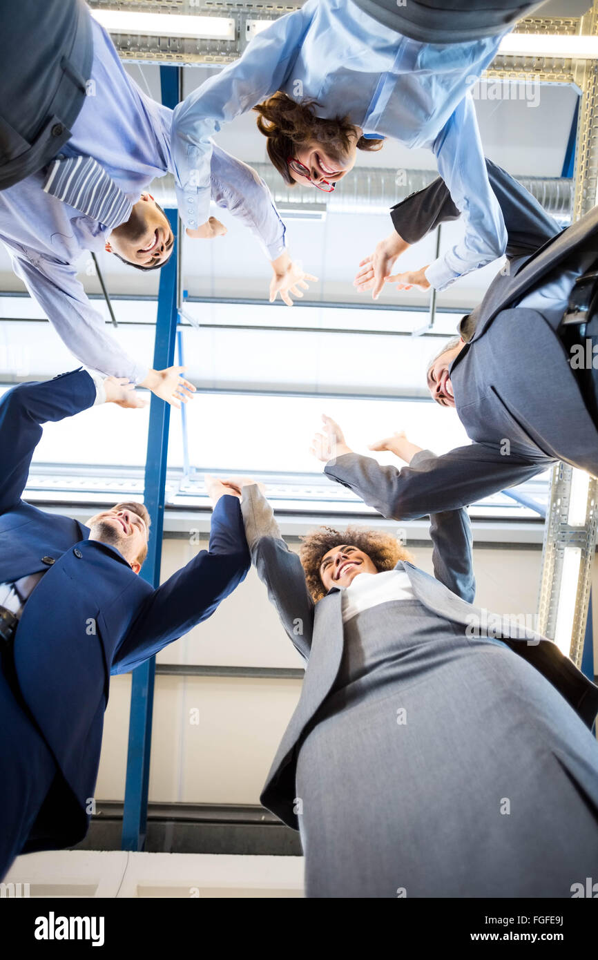 Happy business team high fiving Stock Photo - Alamy