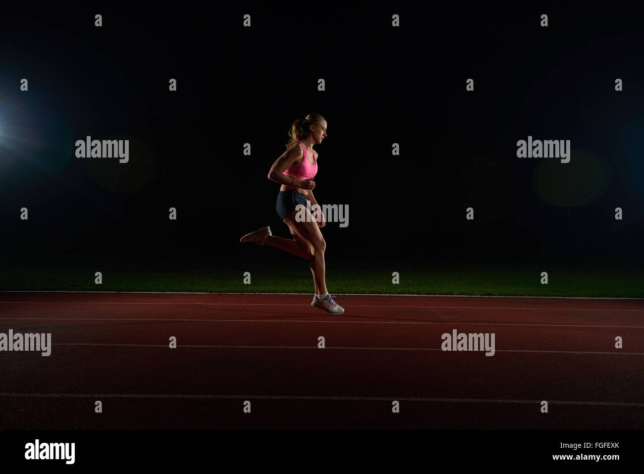 Athletic woman running on track Stock Photo - Alamy