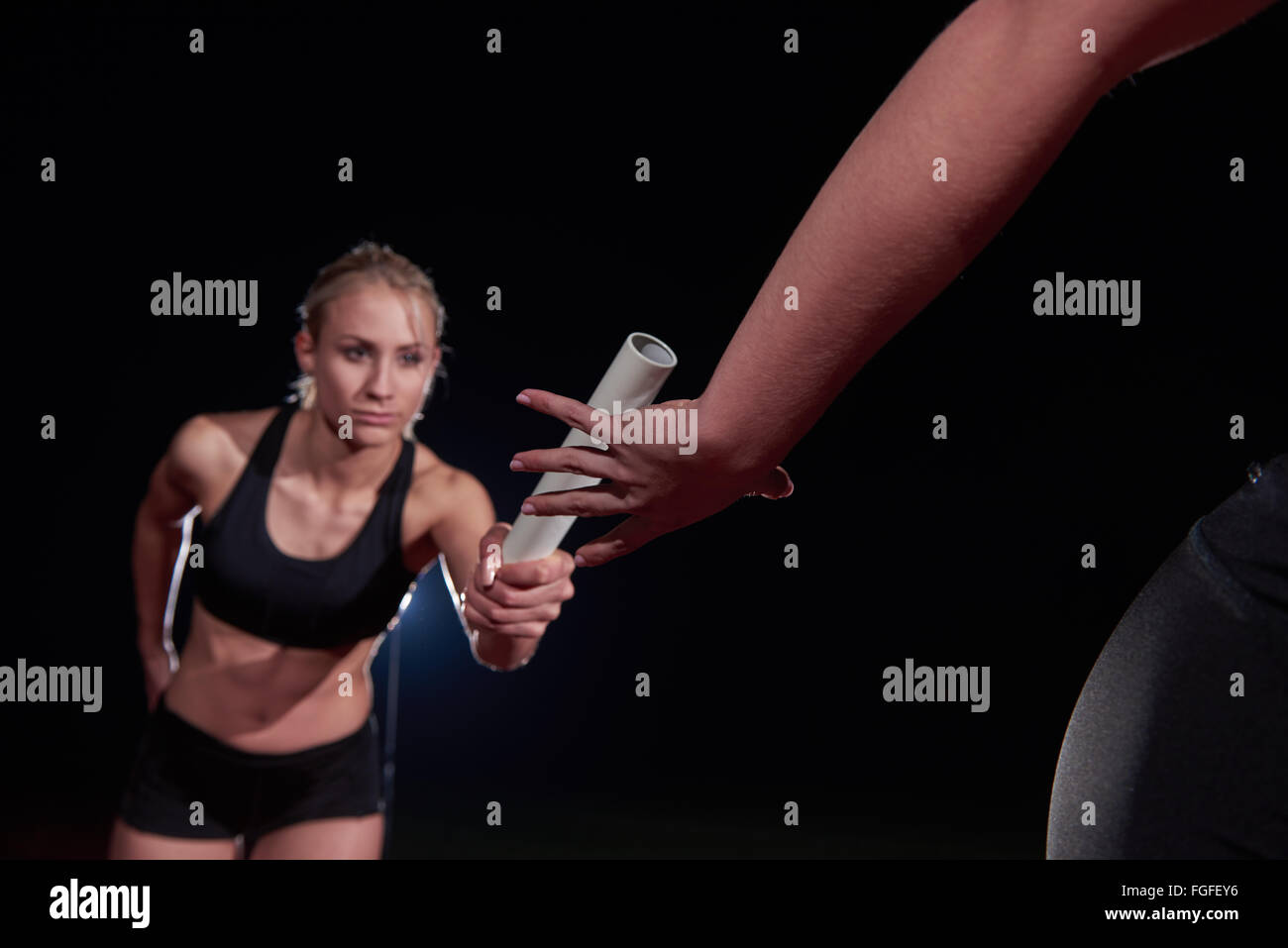 athletic runners passing baton in relay race Stock Photo - Alamy