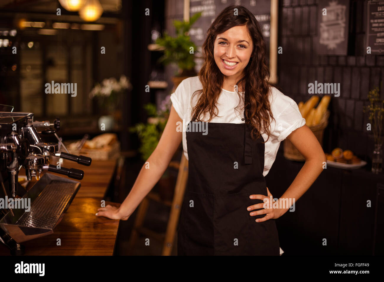 Pretty waitress posing next to coffee machine Stock Photo - Alamy