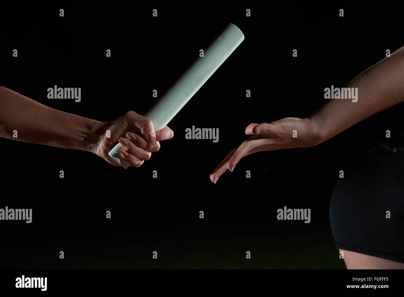 athletic runners passing baton in relay race Stock Photo - Alamy