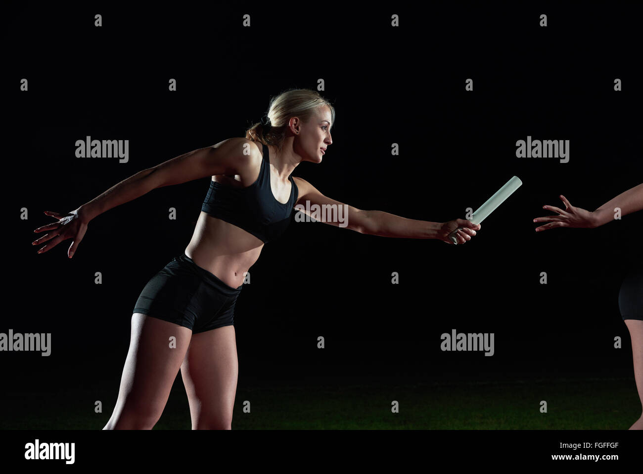 athletic runners passing baton in relay race Stock Photo - Alamy