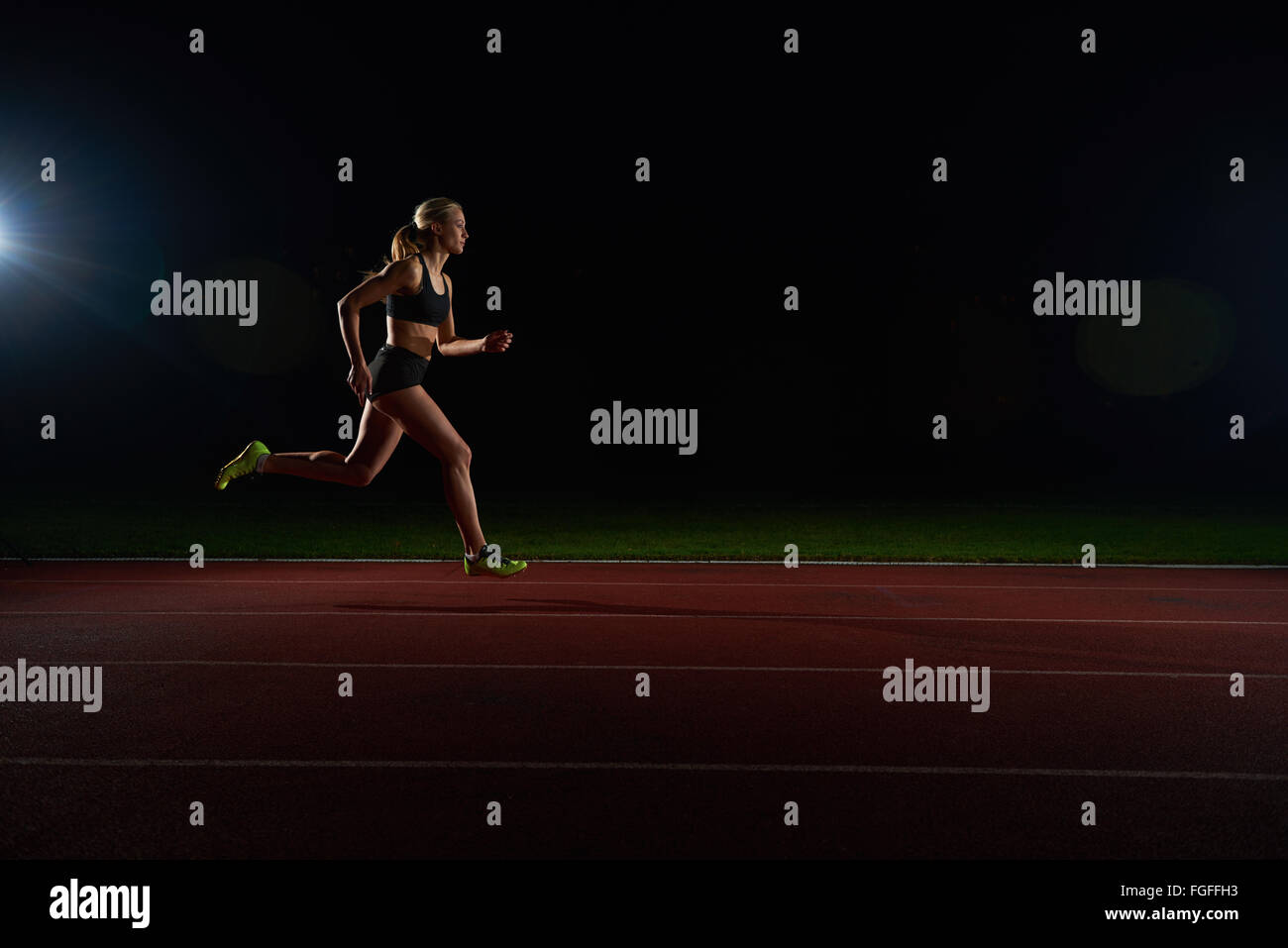 Athletic woman running on track Stock Photo - Alamy