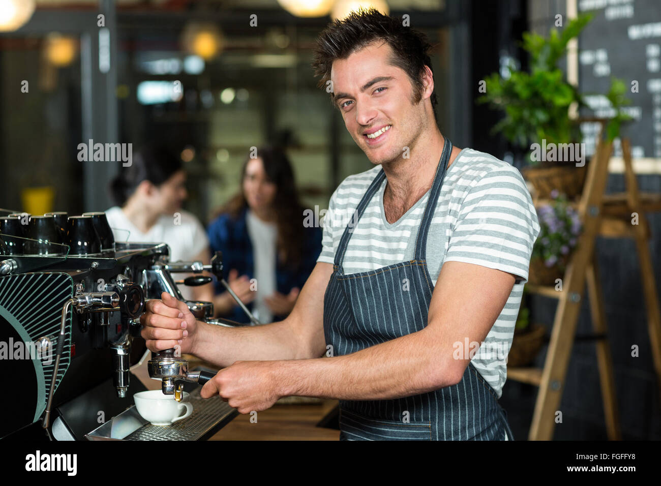 Smiling barista making coffee Stock Photo - Alamy