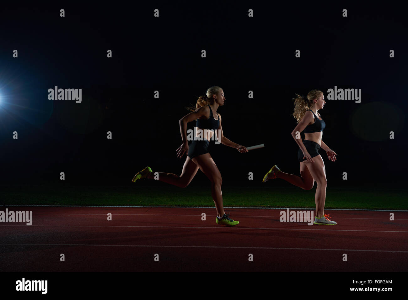 athletic runners passing baton in relay race Stock Photo - Alamy