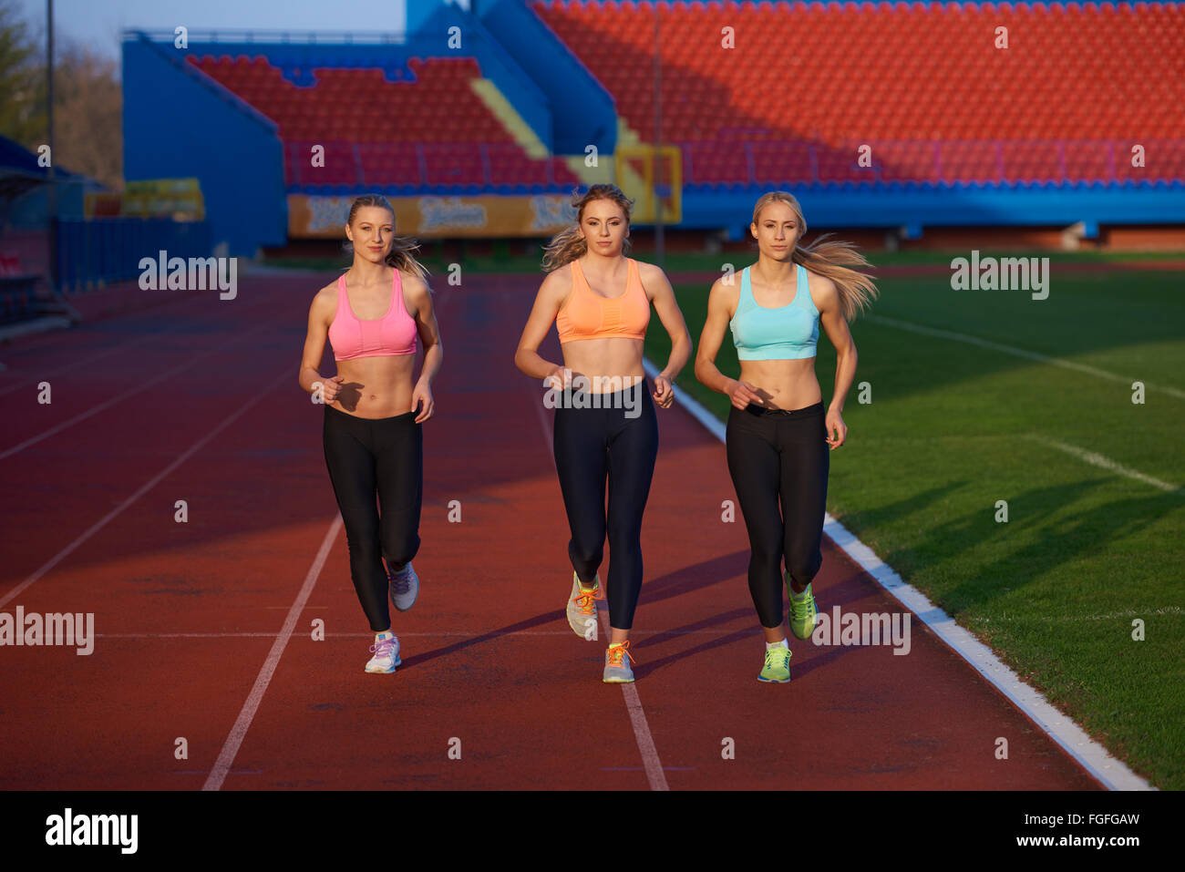 athlete woman group running on athletics race track Stock Photo - Alamy