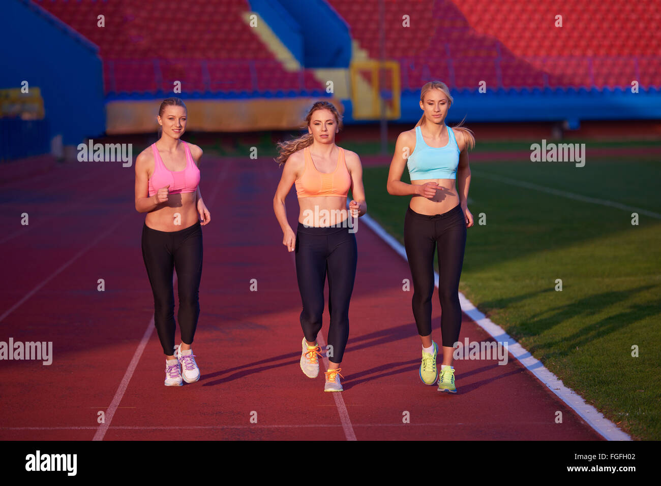 athlete woman group running on athletics race track Stock Photo - Alamy
