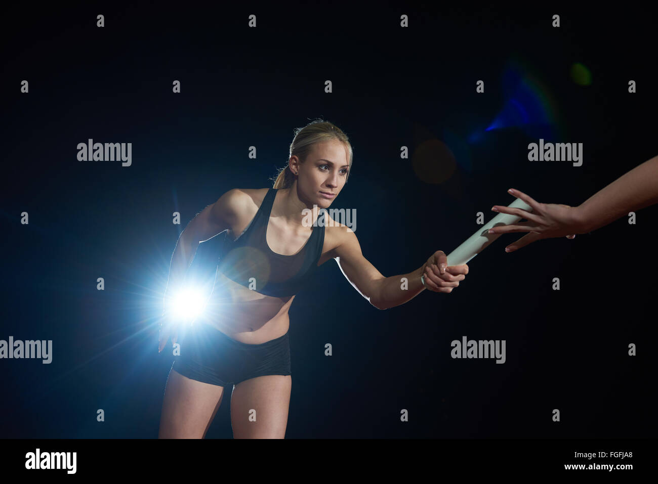 athletic runners passing baton in relay race Stock Photo - Alamy