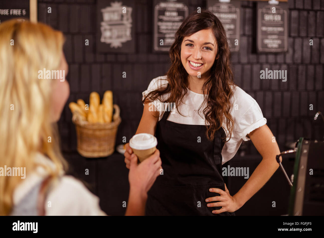 Pretty waitress giving cup of coffee to customer Stock Photo - Alamy
