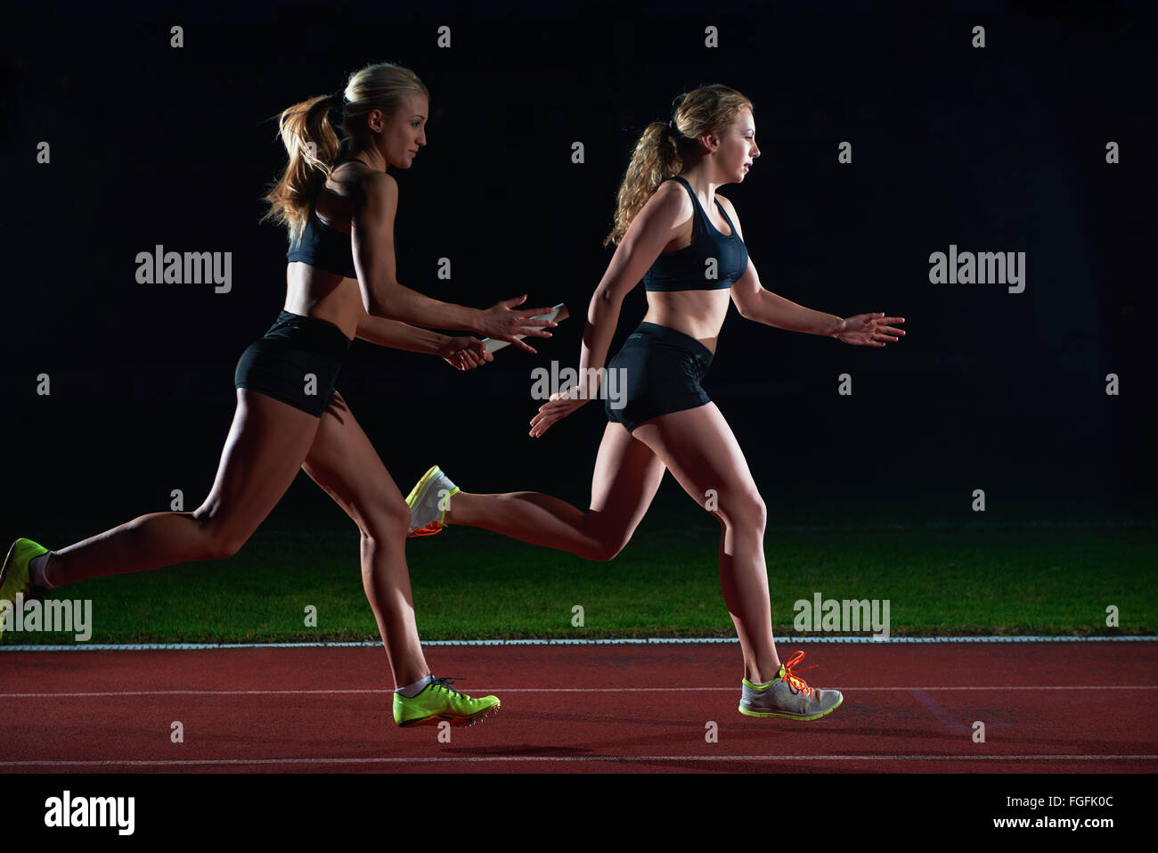 athletic runners passing baton in relay race Stock Photo - Alamy