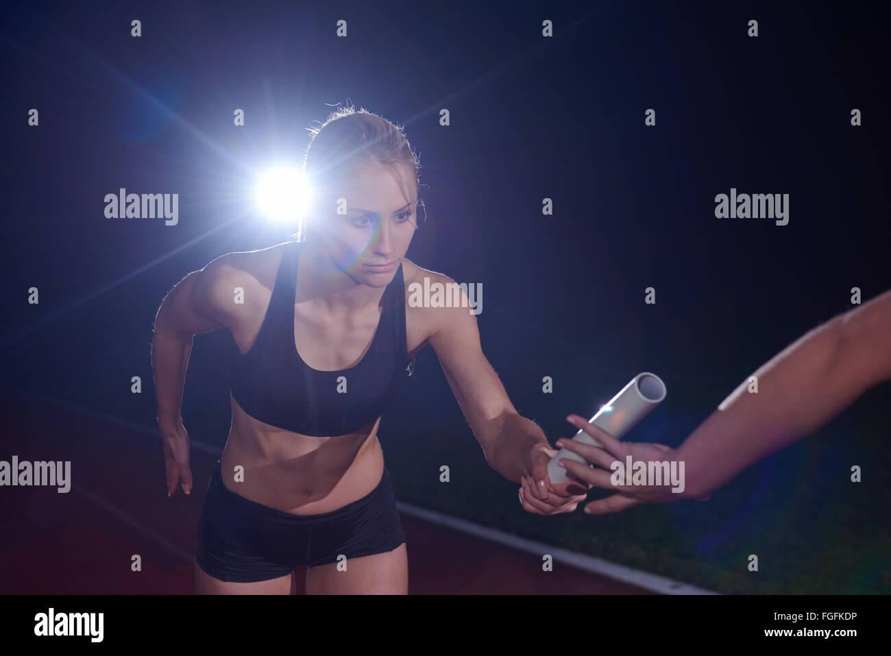 athletic runners passing baton in relay race Stock Photo - Alamy