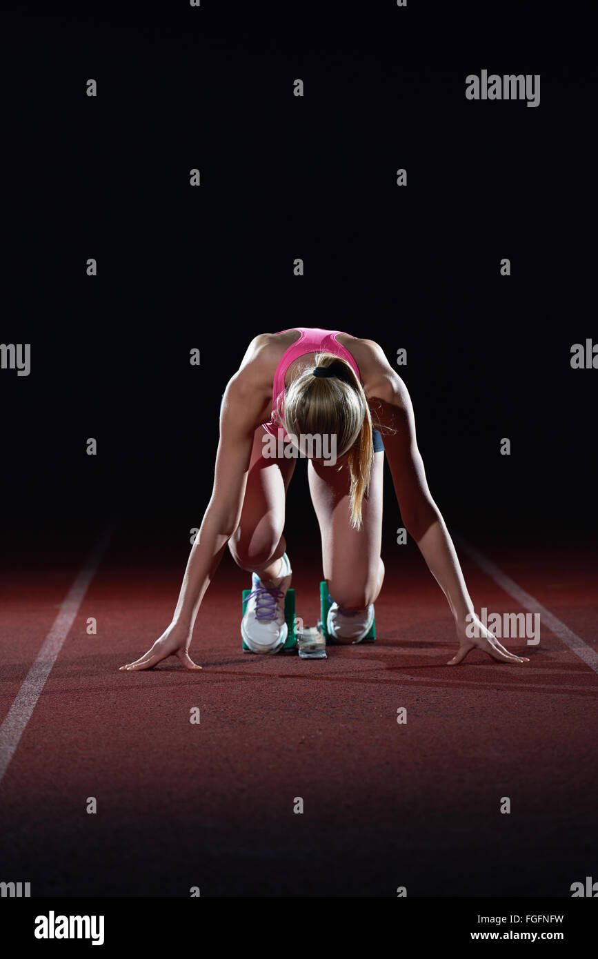 woman sprinter leaving starting blocks Stock Photo - Alamy