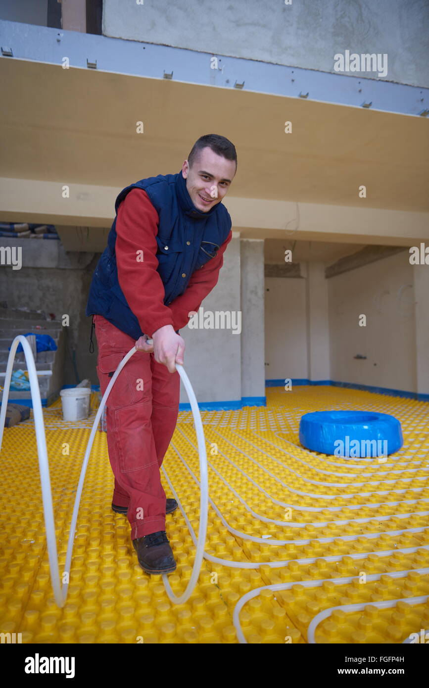 workers installing underfloor heating system Stock Photo - Alamy