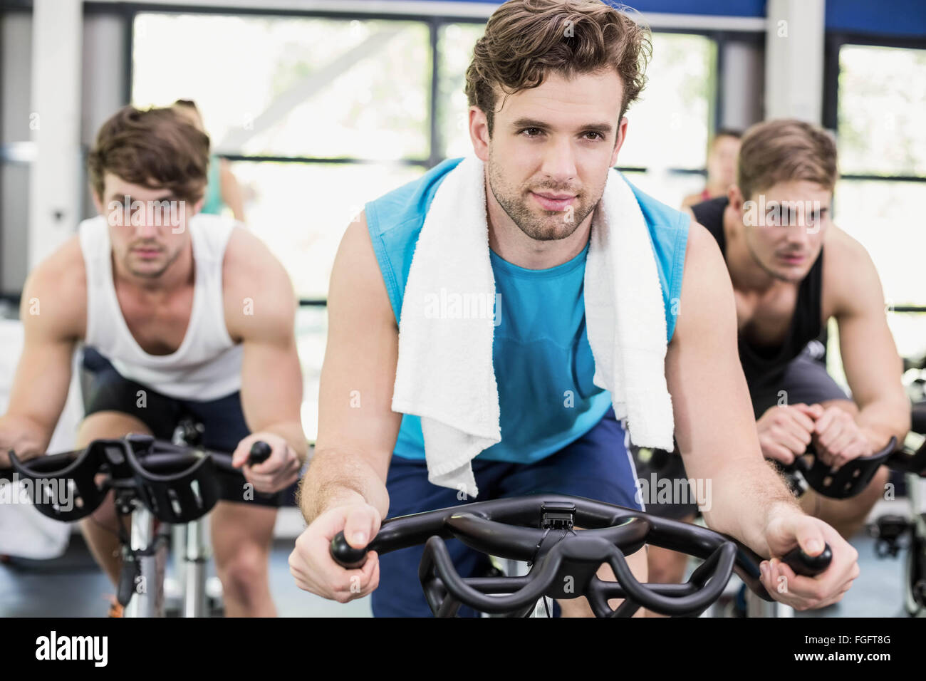 Fit group of people using exercise bike together Stock Photo - Alamy