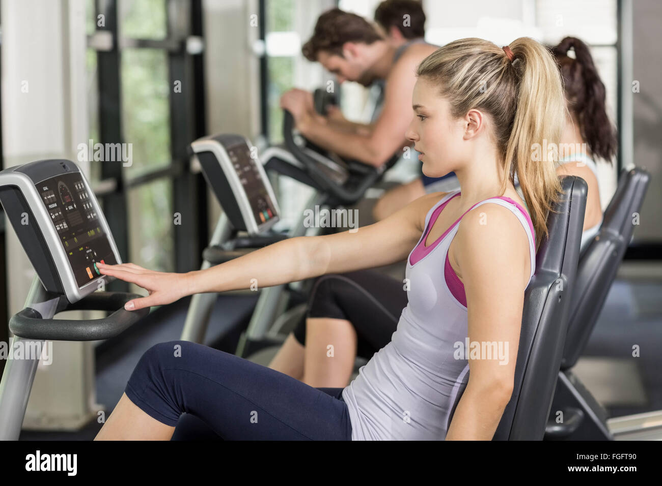 Fit people doing exercise bike Stock Photo - Alamy