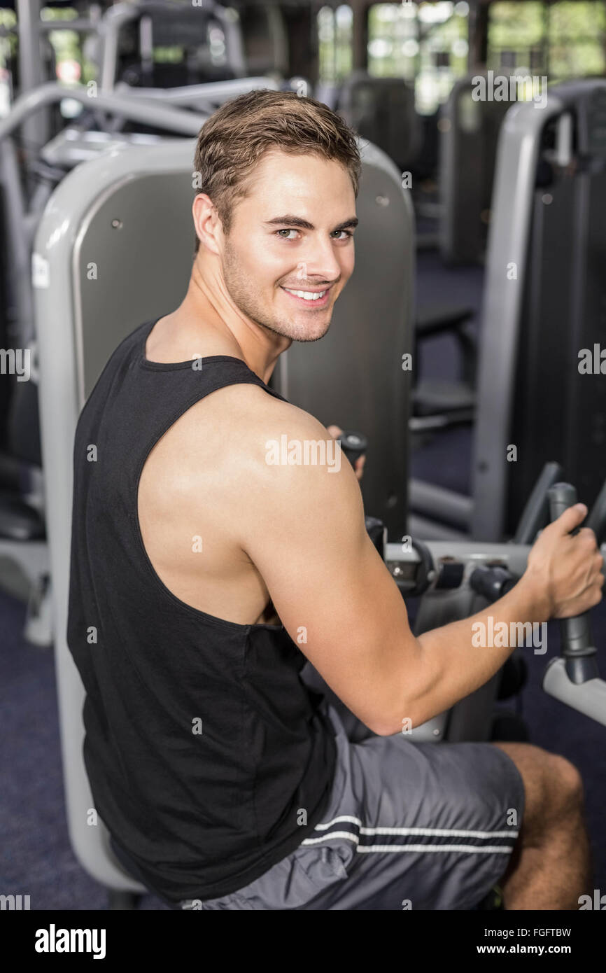 Fit man using weight machine Stock Photo - Alamy