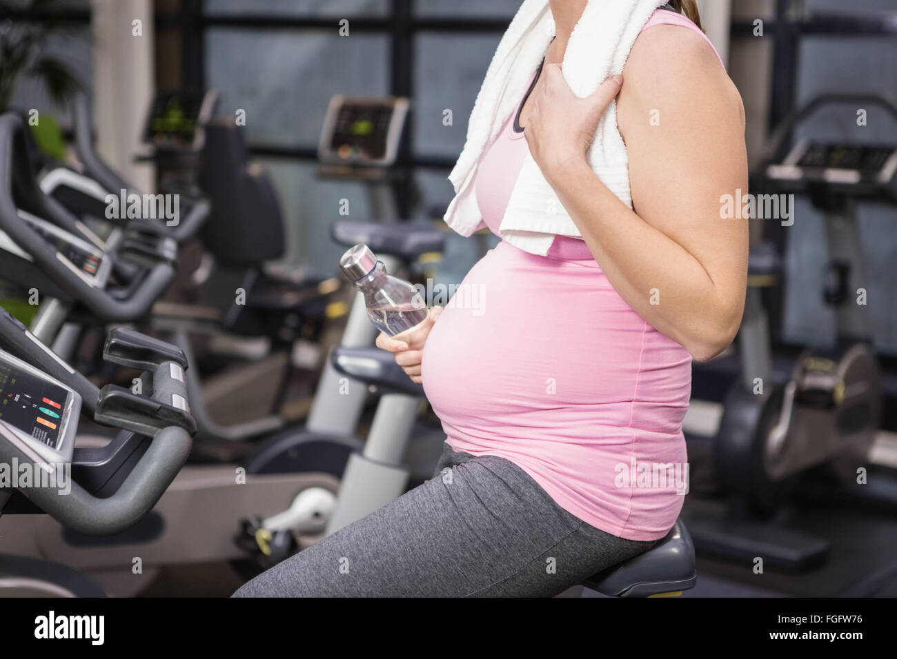 Mid section of pregnant woman on exercise bike Stock Photo - Alamy