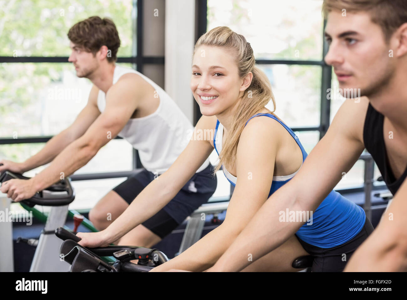 Fit group of people using exercise bike together Stock Photo - Alamy