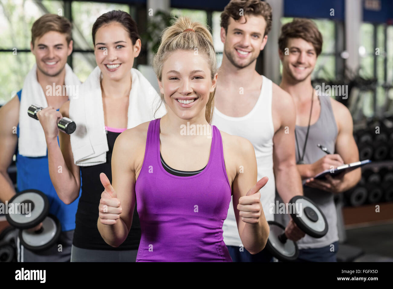 Fitness group lifting dumbbells and showing thumbs up Stock Photo - Alamy