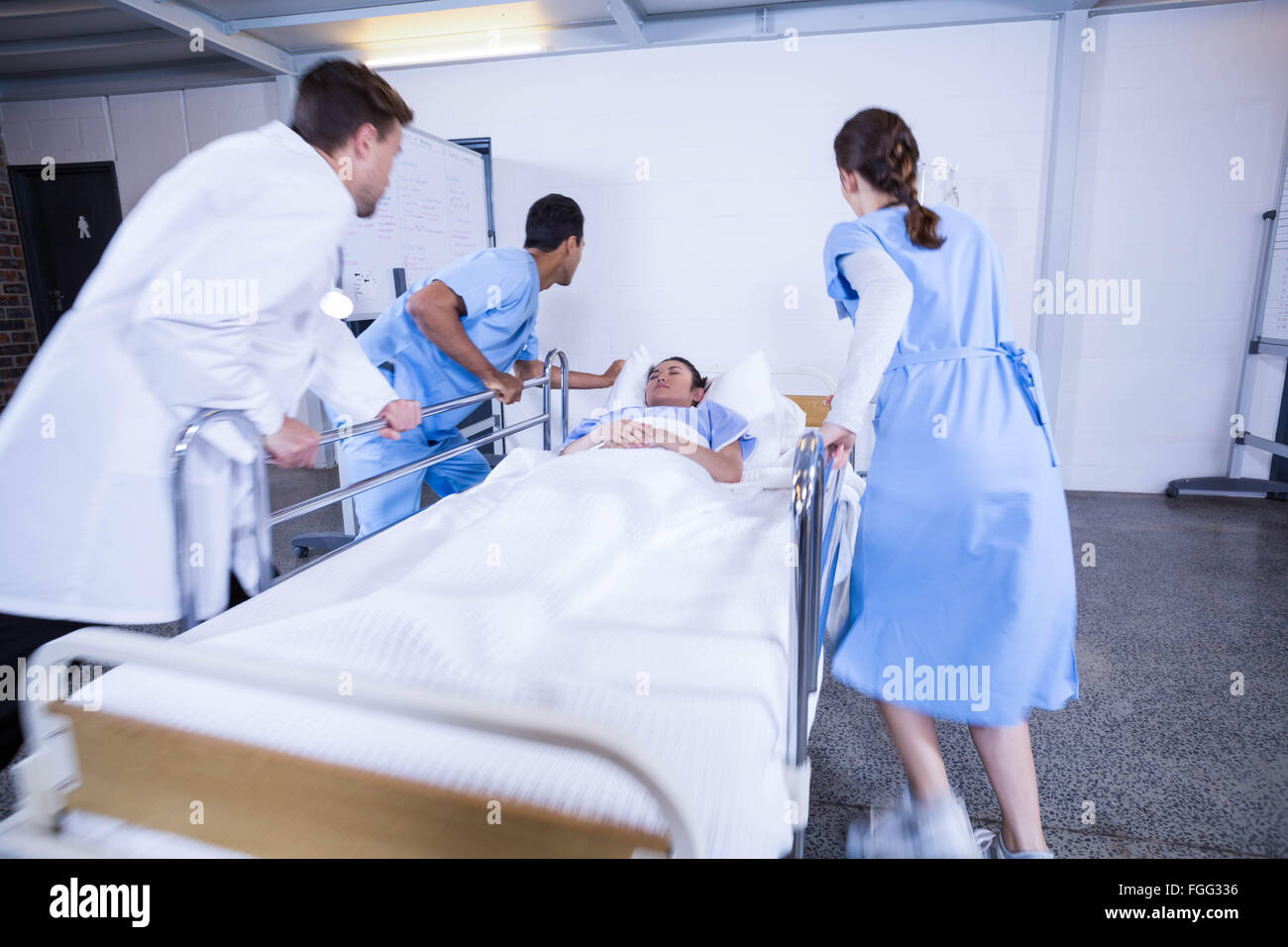 Doctors standing near patient bed Stock Photo - Alamy