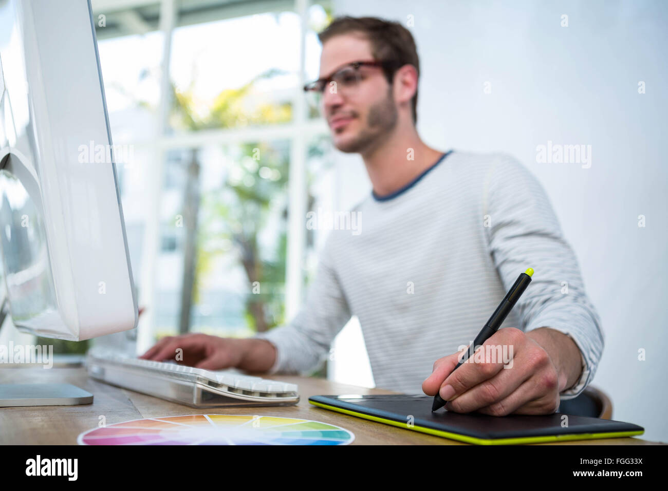 Handsome man working on computer and taking notes Stock Photo - Alamy