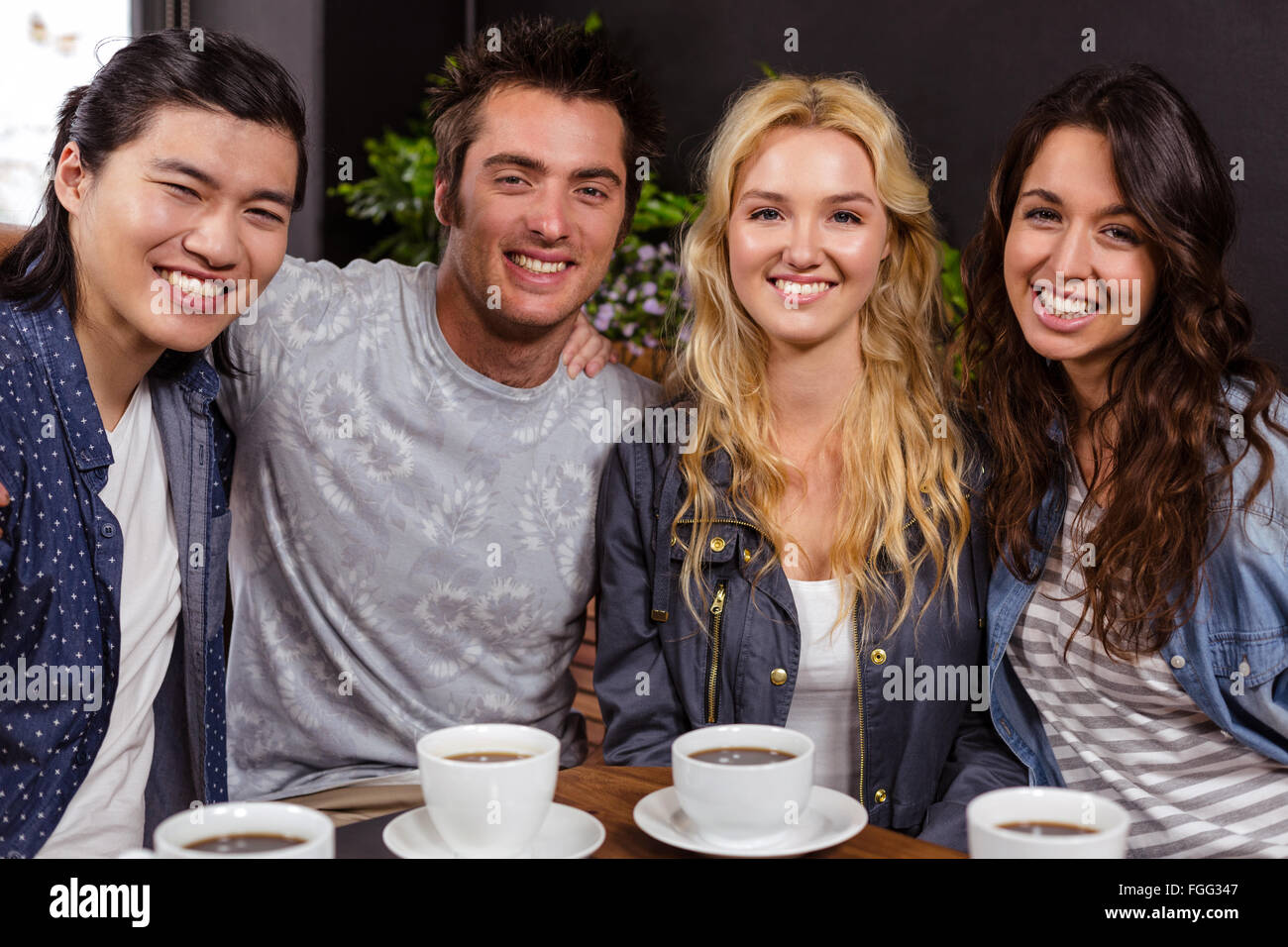 Smiling friends enjoying coffee together Stock Photo - Alamy