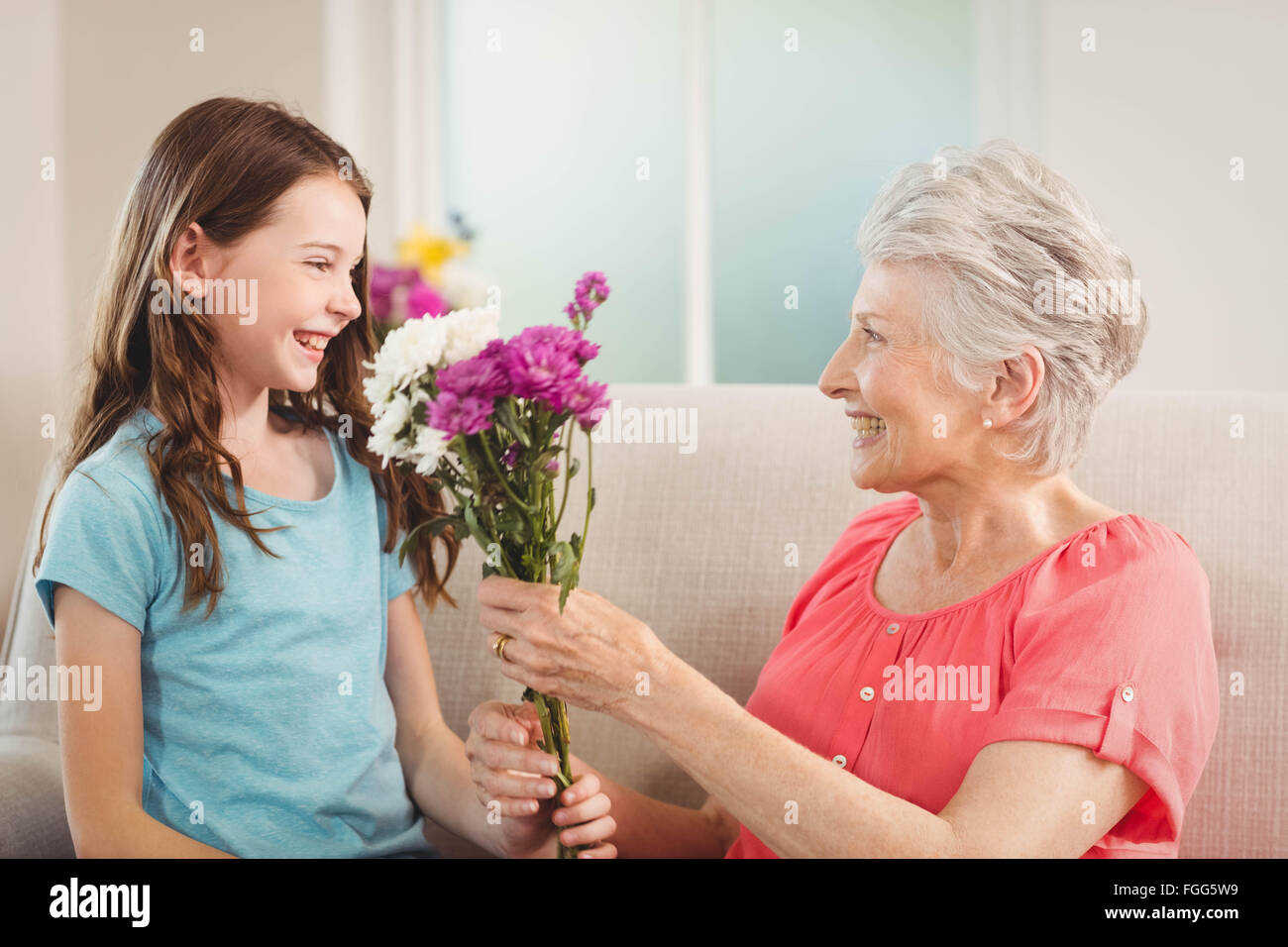 Grandmother giving a bunch of flowers to her granddaughter Stock Photo ...