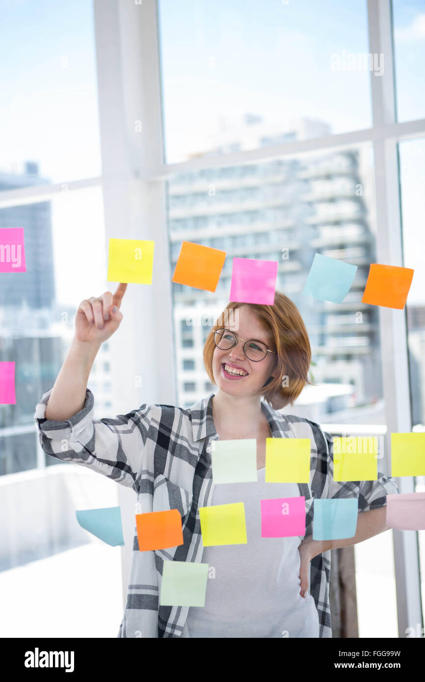 smiling hipster woman sticking notes on a notice board Stock Photo - Alamy