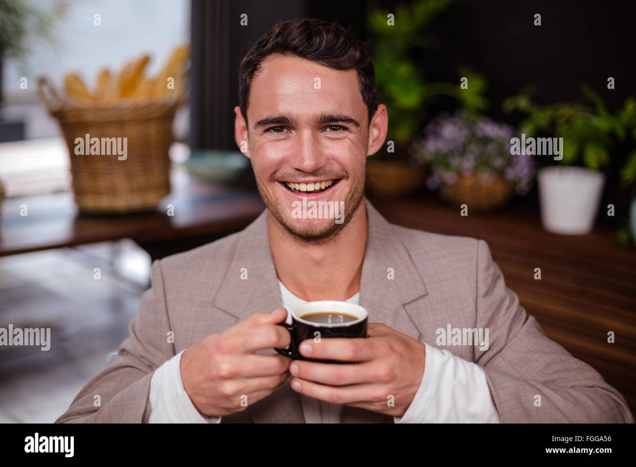 Smiling man is holding a cup of coffee Stock Photo - Alamy