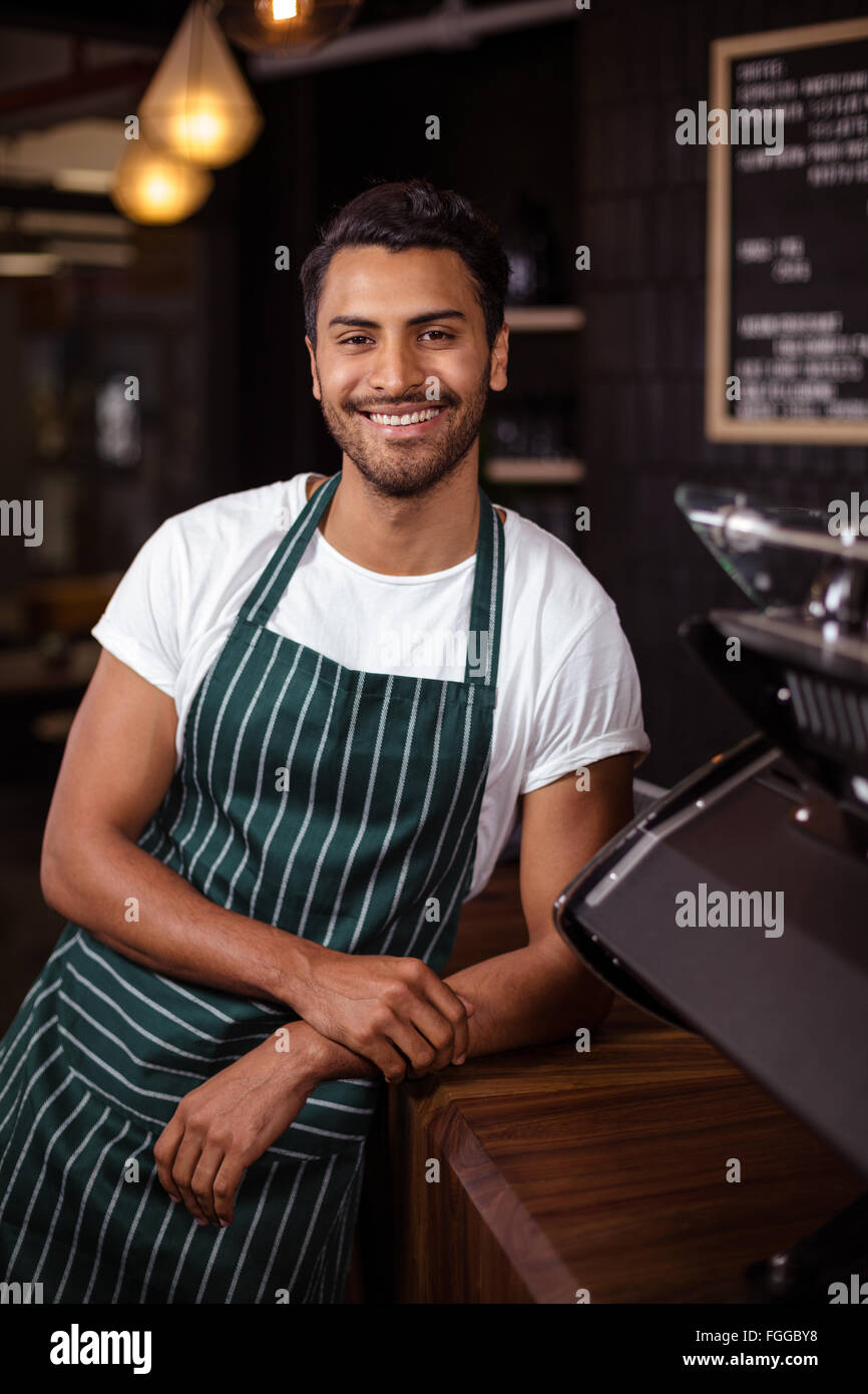 Smiling barista leaning against counter Stock Photo - Alamy