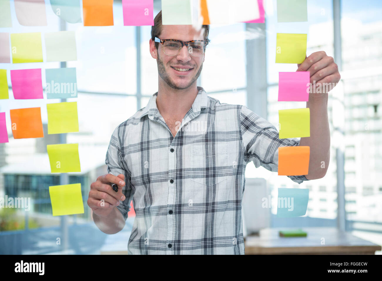 Hipster man looking at post-it Stock Photo - Alamy