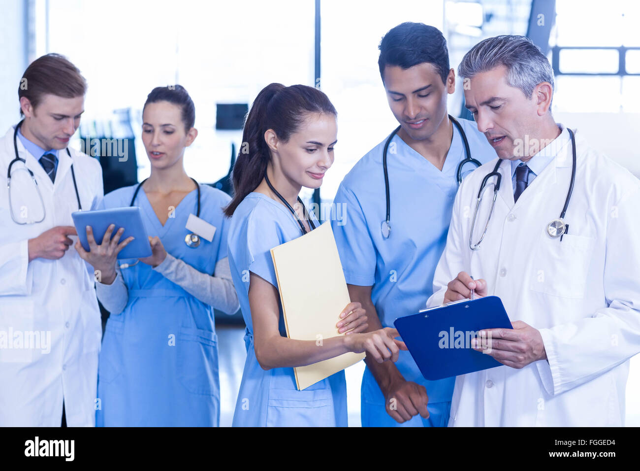 Medical team discussing paperwork on clipboard Stock Photo - Alamy