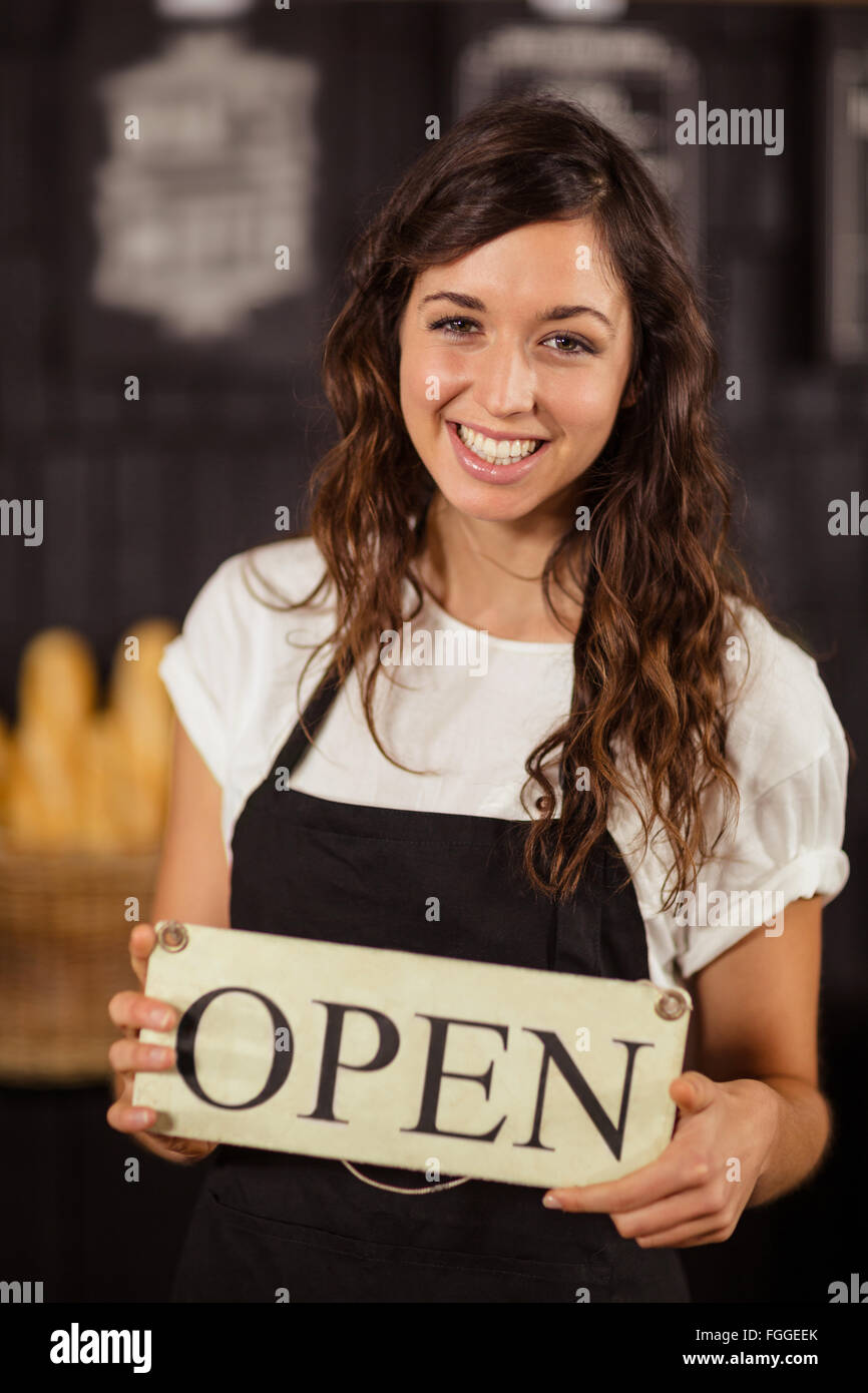 Portrait of a waitress showing open sign Stock Photo - Alamy