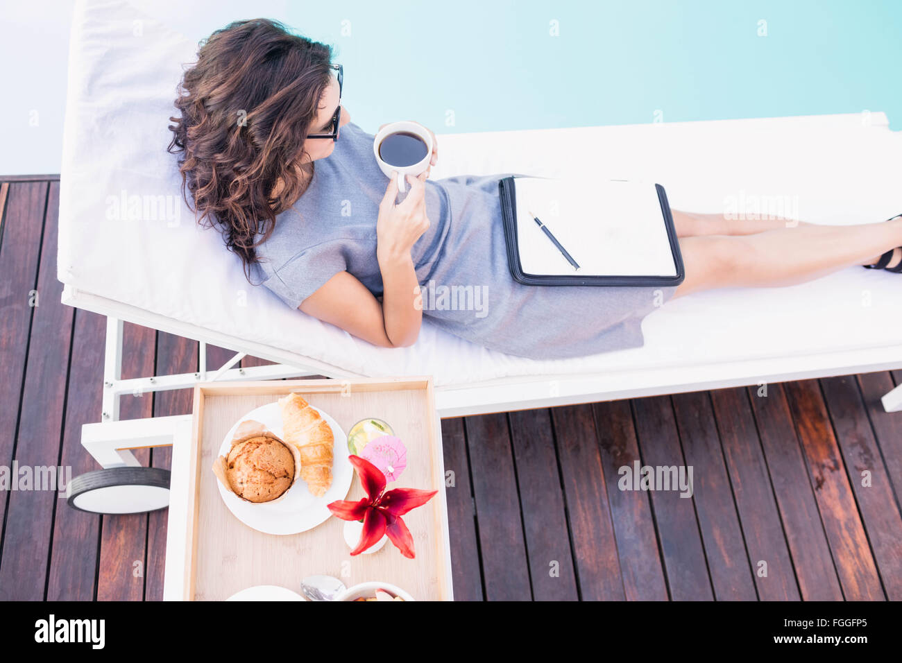 Young woman having cup of tea near poolside Stock Photo - Alamy